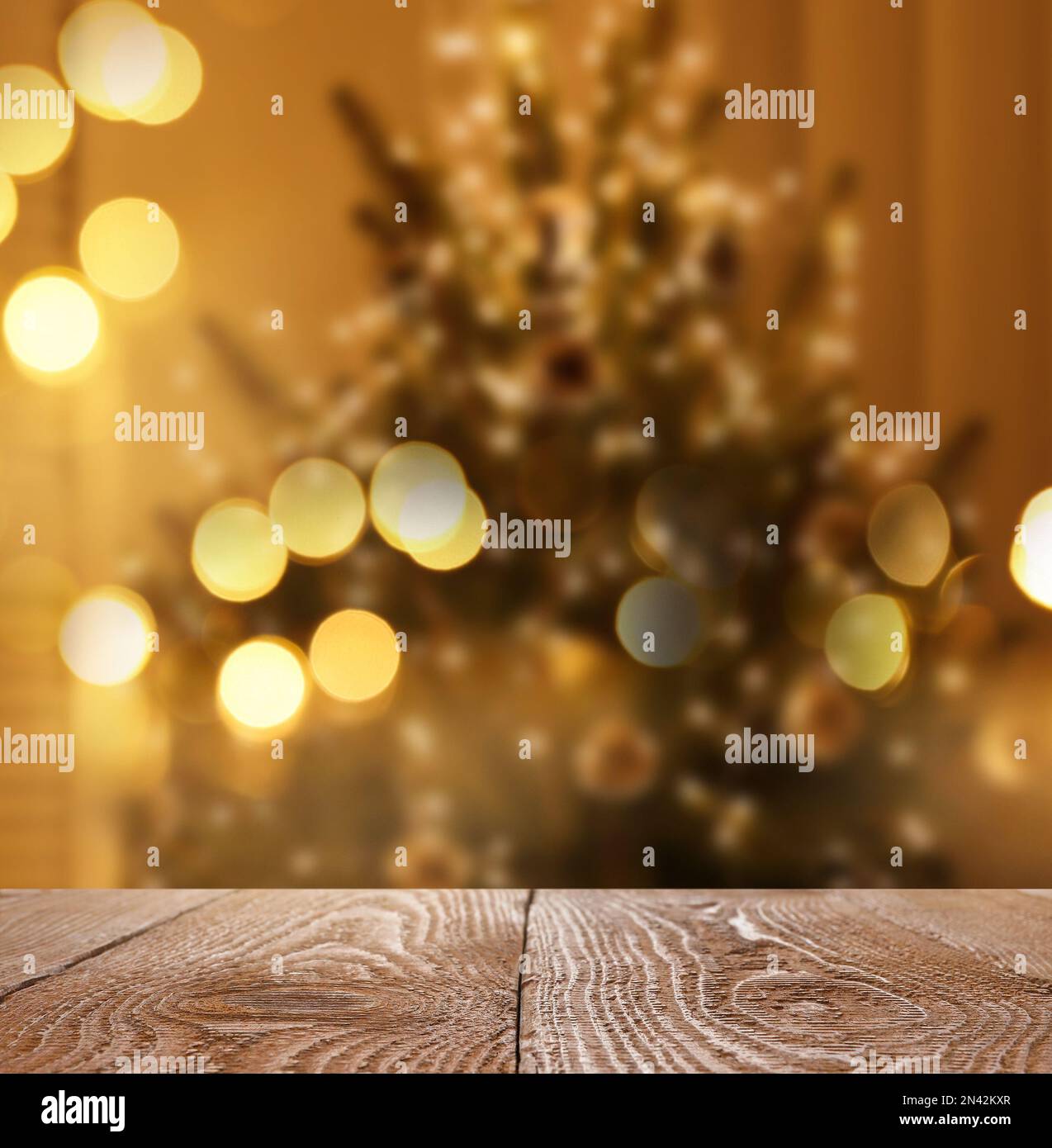 Empty wooden surface and blurred view of Christmas tree in room, space ...