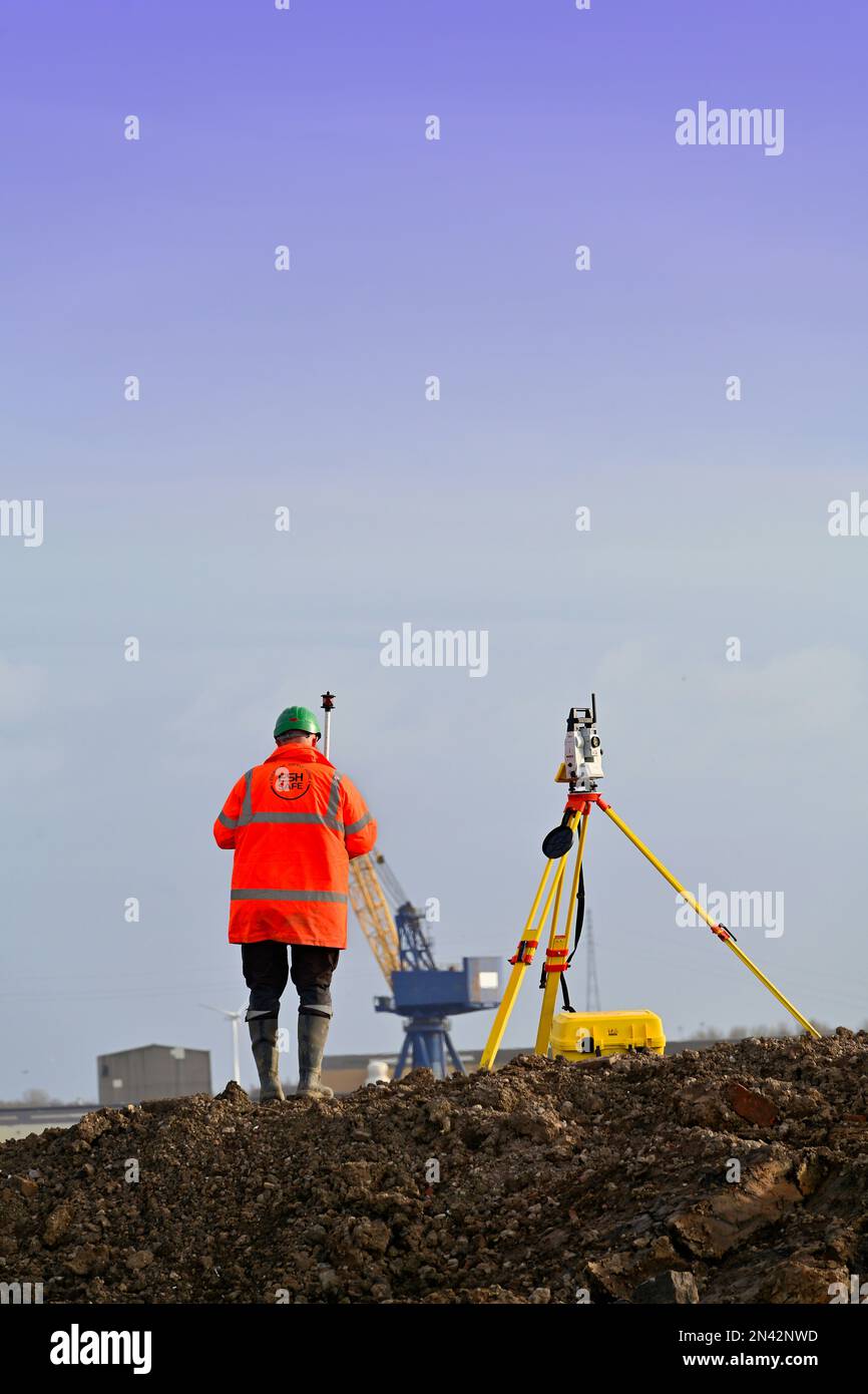 A surveyor using a theodolite to landscape the area before developing ...