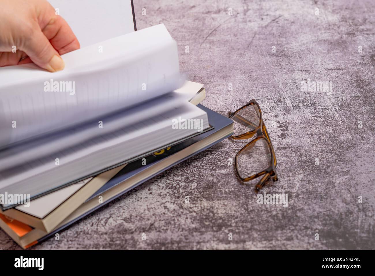 woman's hand turning the pages of a book with an out-of-focus ...