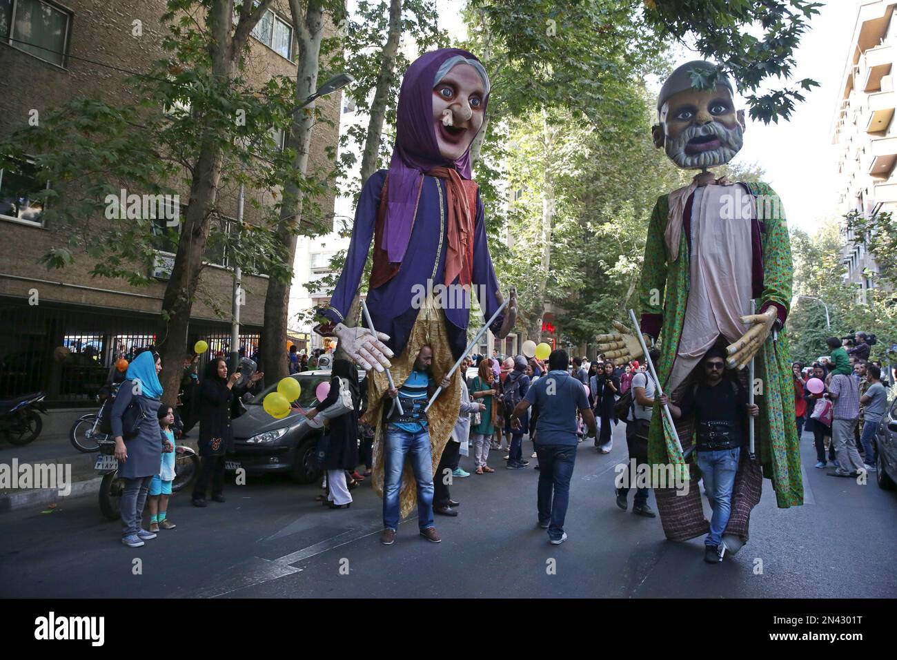 Iranian puppeteers display two huge puppets depicting an elderly ...