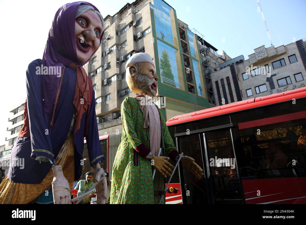 Two huge puppets of an elderly Iranian couple wearing traditional dress ...