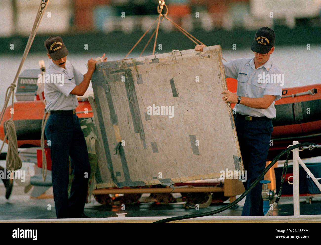 Two U.S. Coast Guard crewmen unload an interior piece from United ...