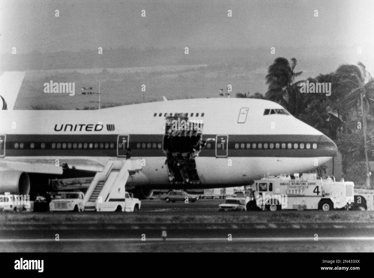 Two inspectors look at the severely damaged United Airlines 747 at ...