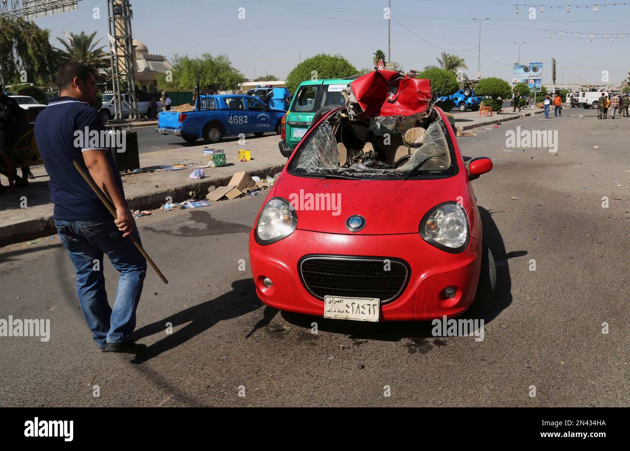 A man inspects his damaged car at the scene of a car bomb explosion in ...