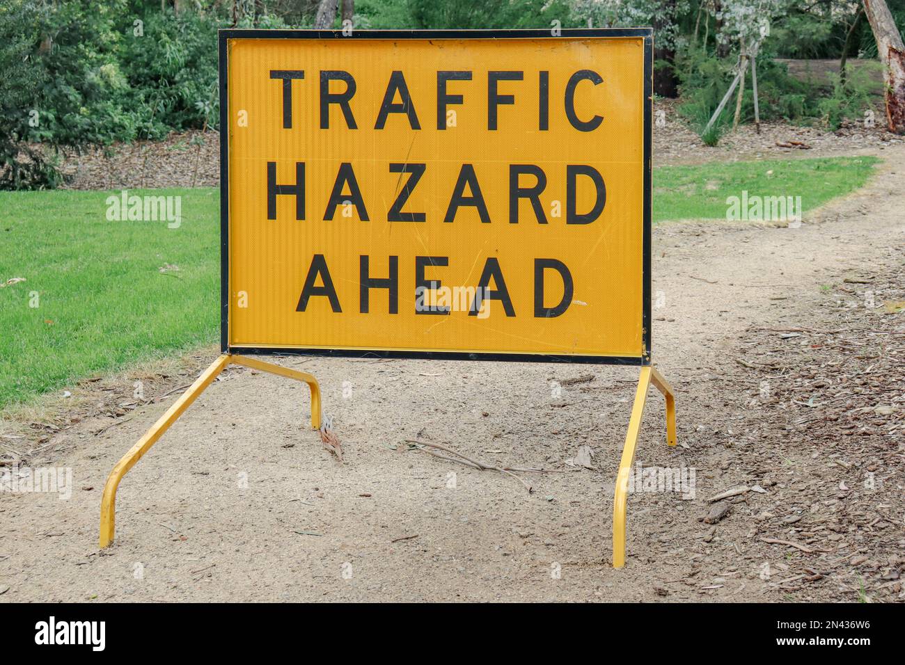 A large yellow TRAFFIC HAZAR AHEAD sign on a path Stock Photo - Alamy