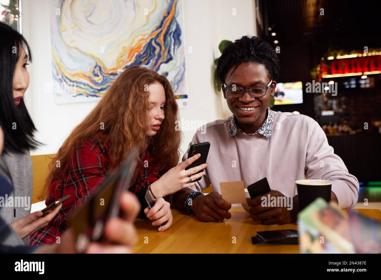 Multiracial friends girls and guys having fun laughing drinking coffee ...