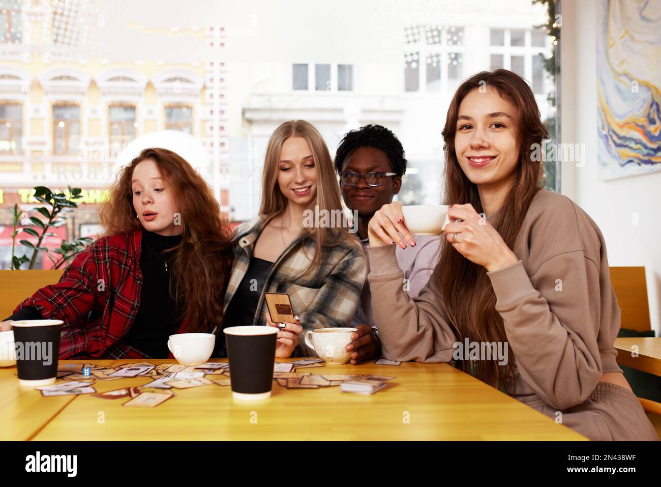 Multiracial friends girls and guys having fun laughing drinking coffee ...