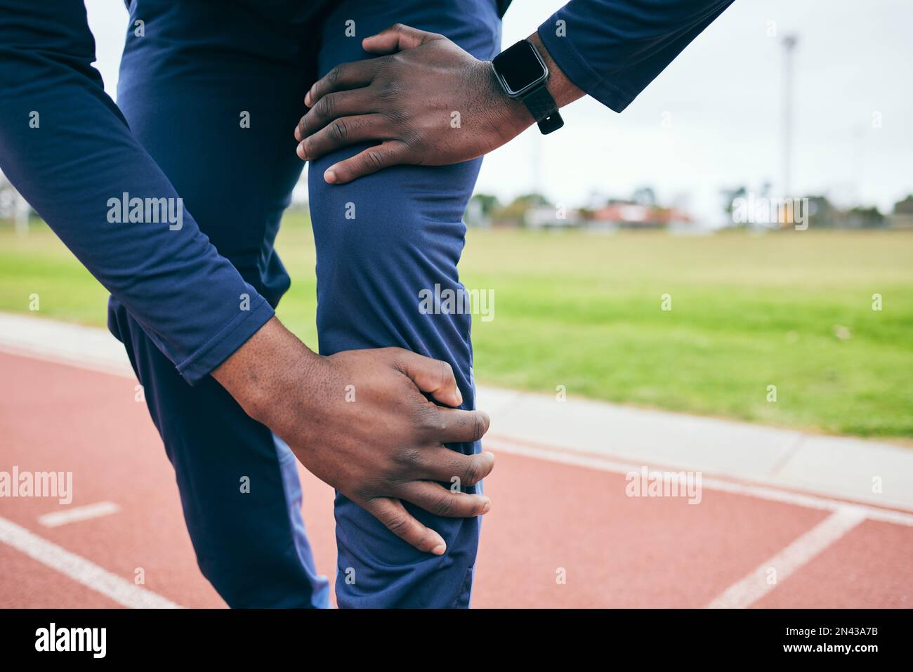 Knee pain, injury and black man runner, fitness and race in stadium ...