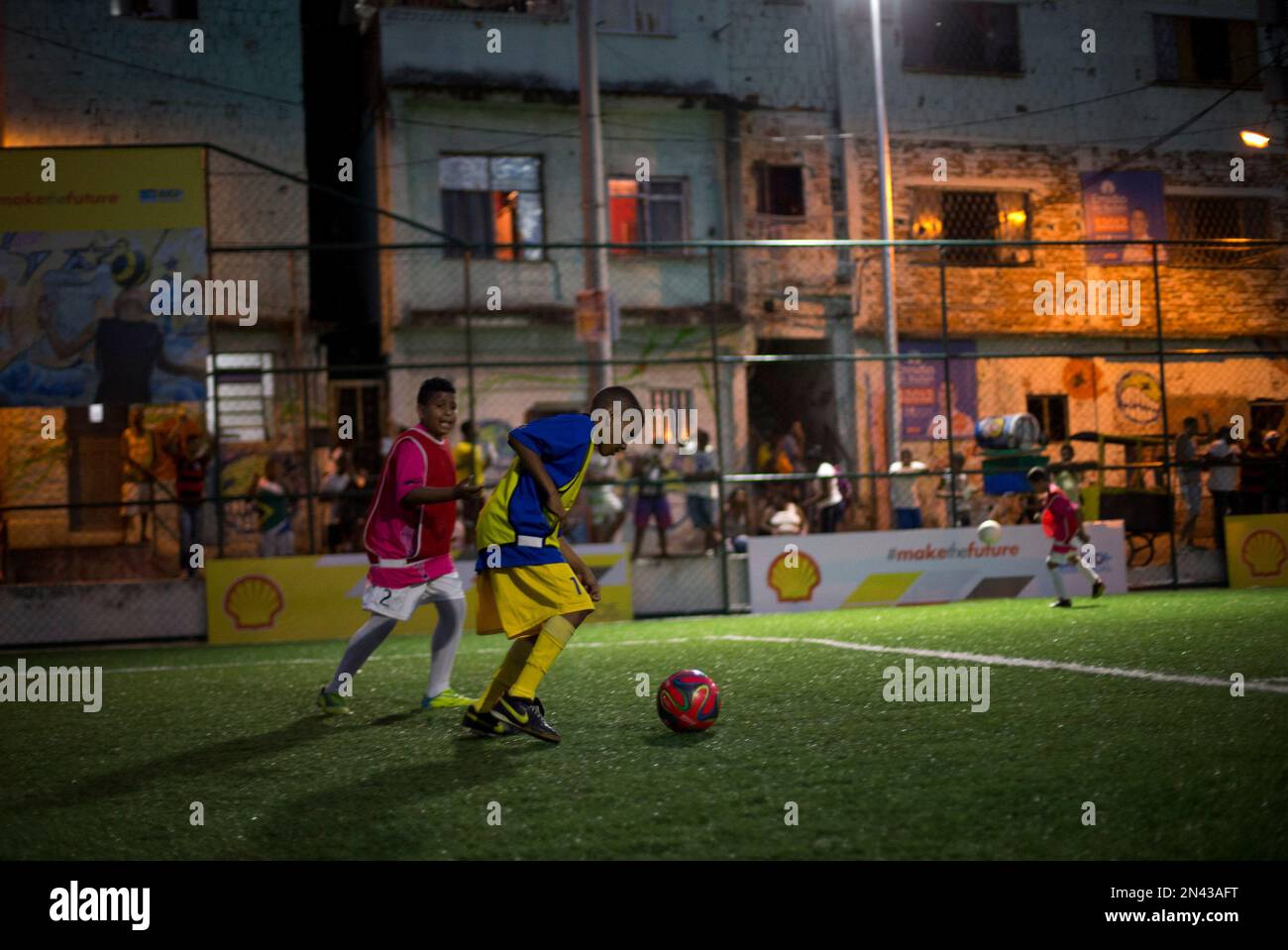 Children play soccer at the newly installed pitch powered by their ...