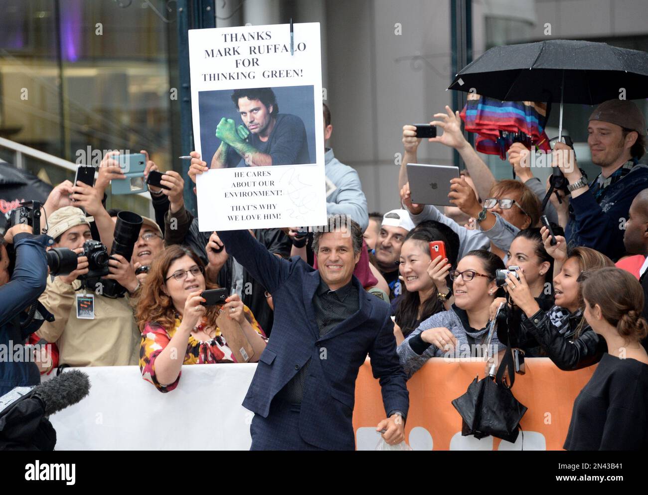 Mark Ruffalo holds a sign as he arrives at the premiere of "Infinitely ...