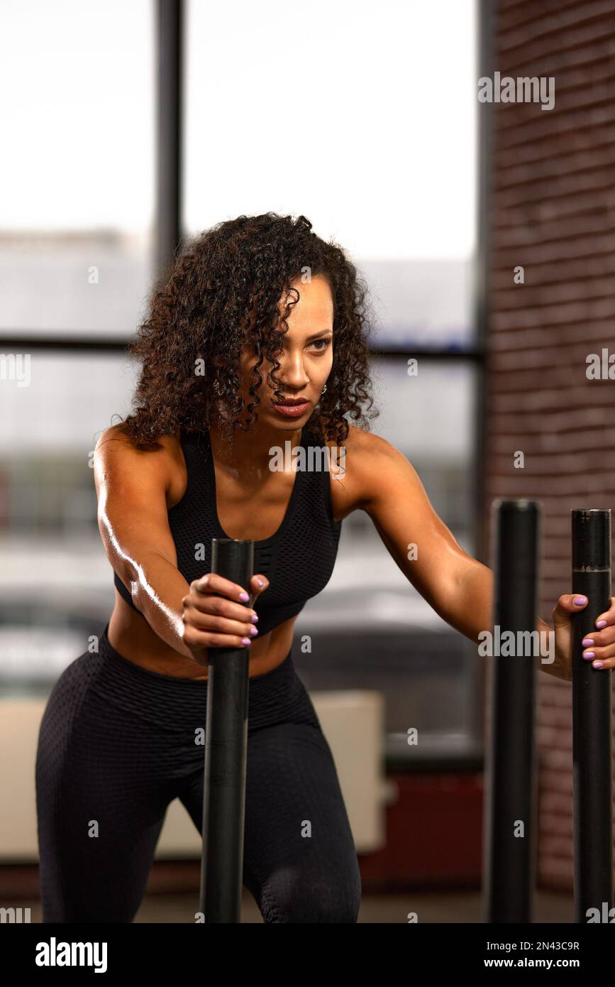 African American fitness trainer pulls a crossfit sled from the ...