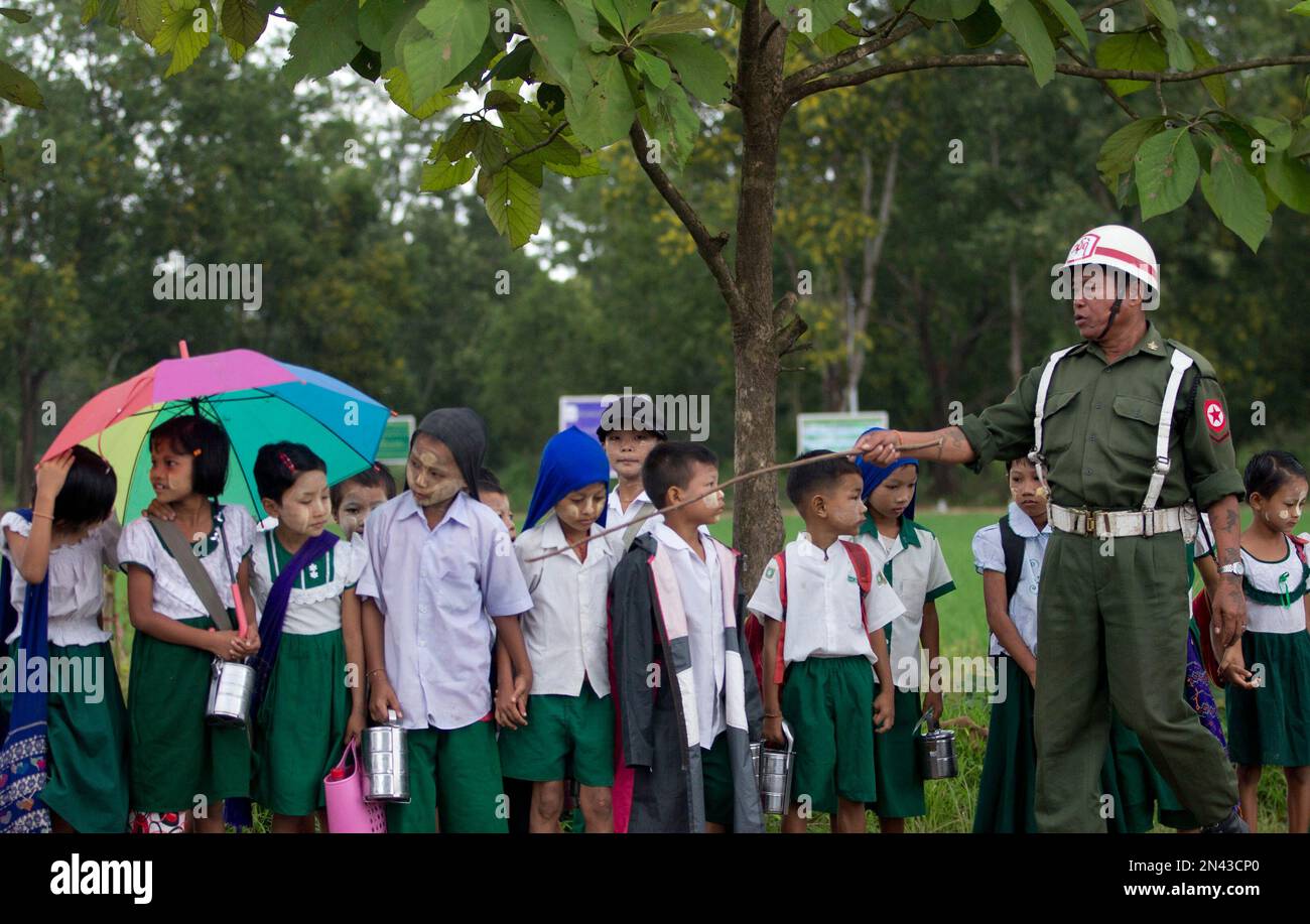A military police officer of Myanmar army uses a stick to guide a group ...