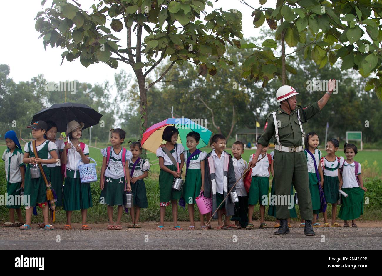 A military police officer of Myanmar army stops traffic to guide a ...