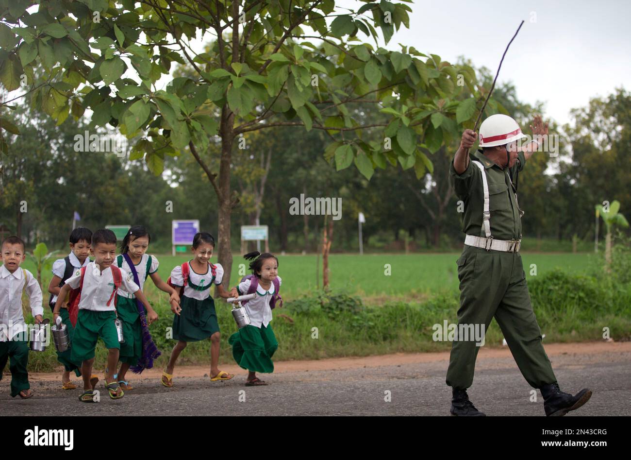 A military police officer of Myanmar army stops traffic to guide a ...