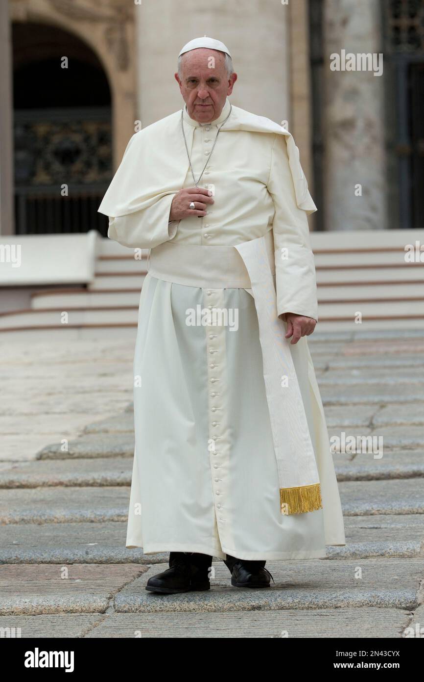 Pope Francis touches his cross as he walks down the steps of St. Peter ...