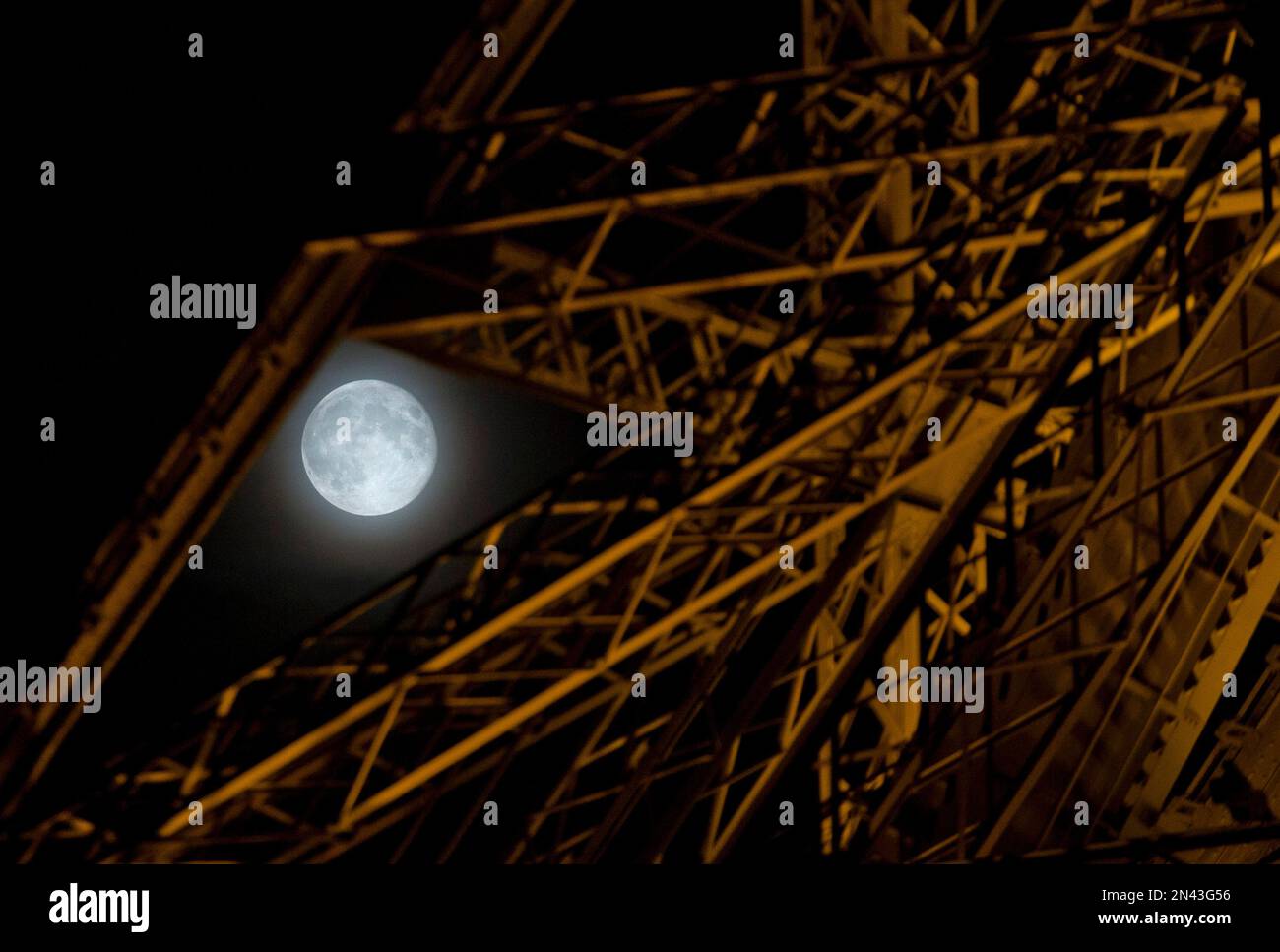 The full moon rises through the Eiffel Tower in Paris, Tuesday, Sept. 9 ...