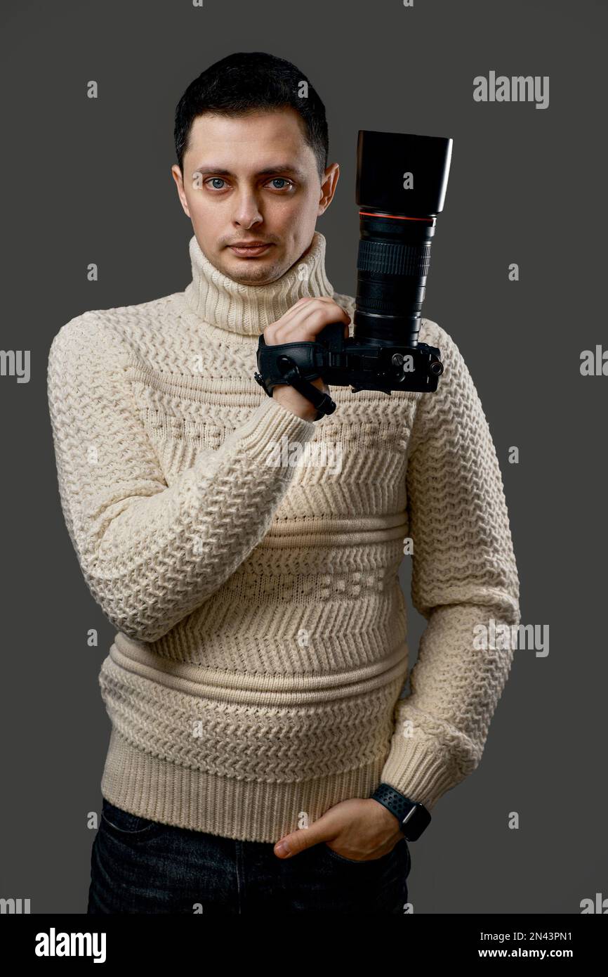 Professional photographer with a camera on gray background Stock Photo ...