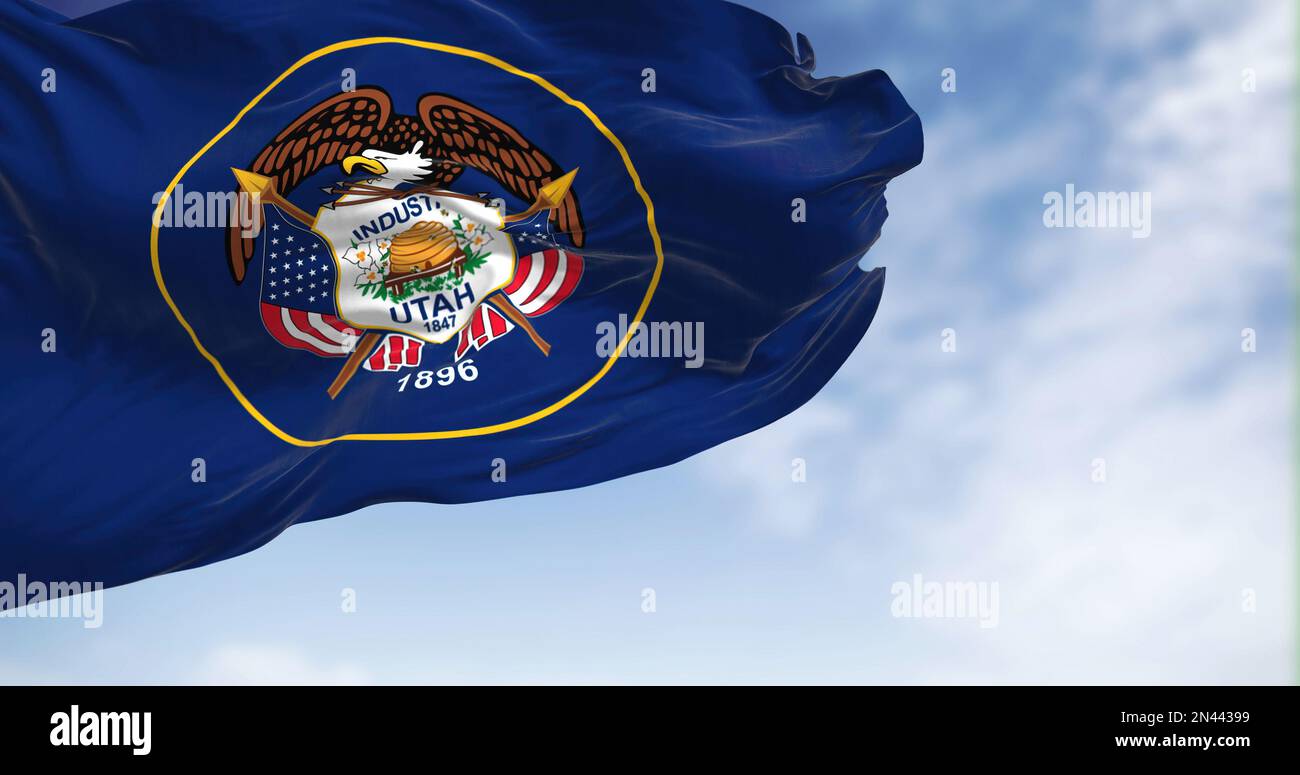 The Utah state flag fluttering in the wind on a sunny day. The Utah ...
