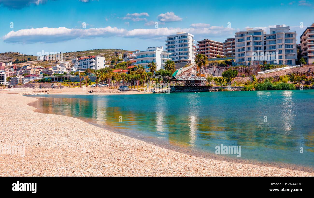 Azure river flowing in to the sea. Bright spring cityscape of Saranda ...