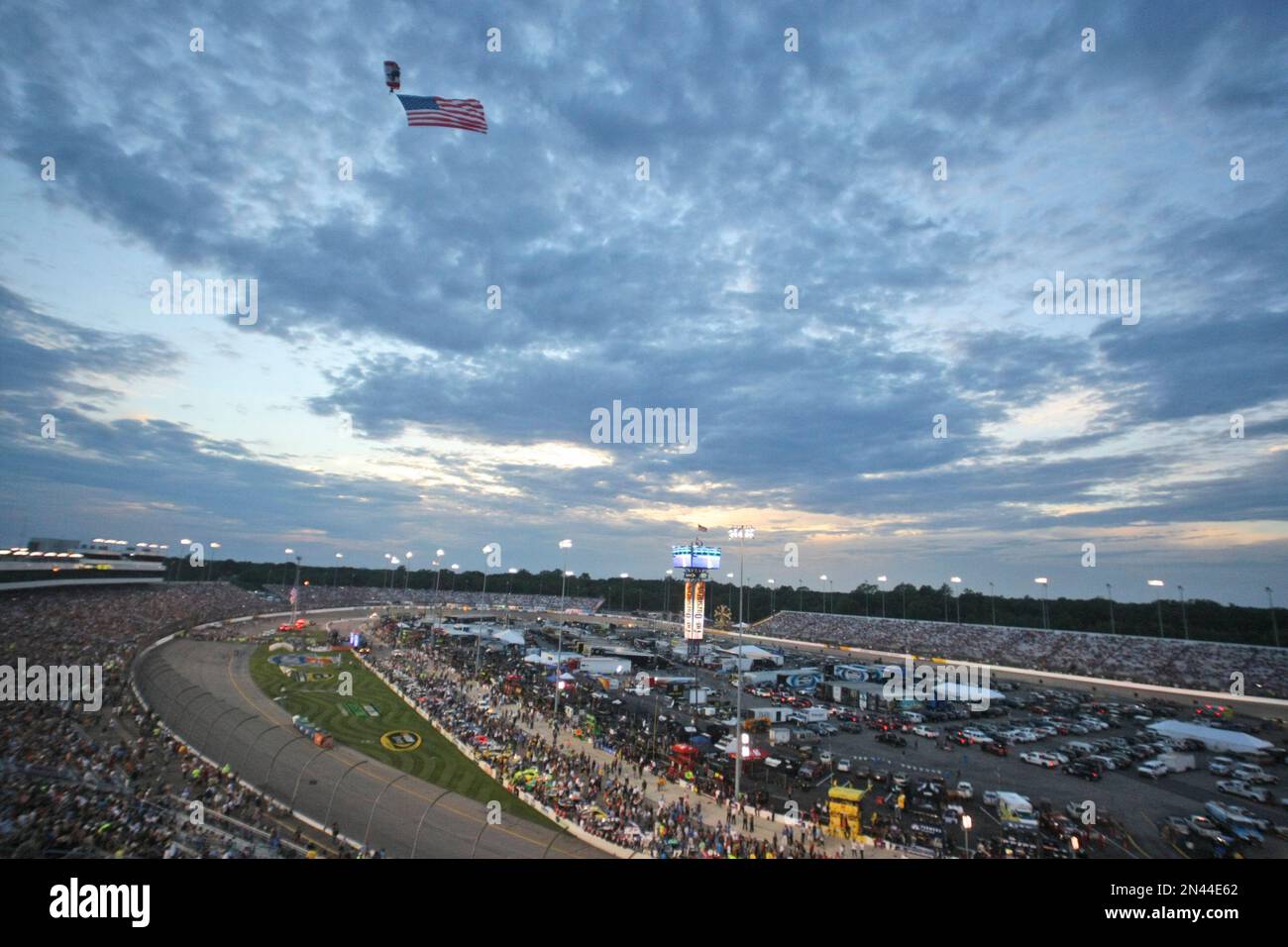 A member of the Army parachute team jumps into the infield with a U.S ...
