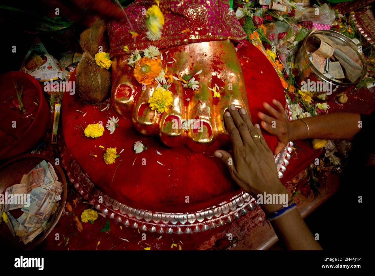 Hindu devotees touch the feet of an idol of elephant-headed Hindu God ...
