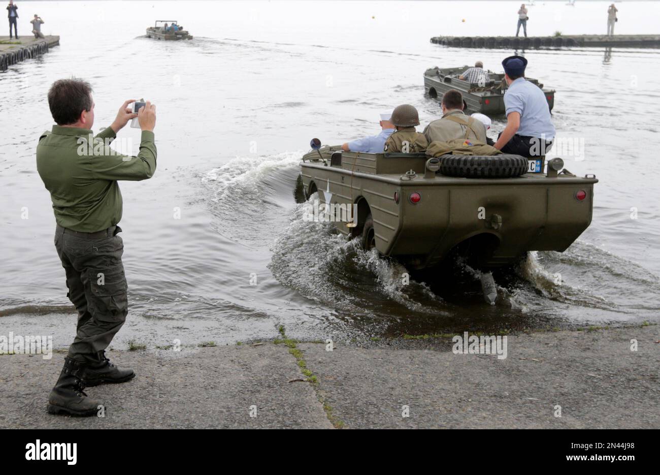 An amphibious army vehicle dated from WWII drives into the water, in ...