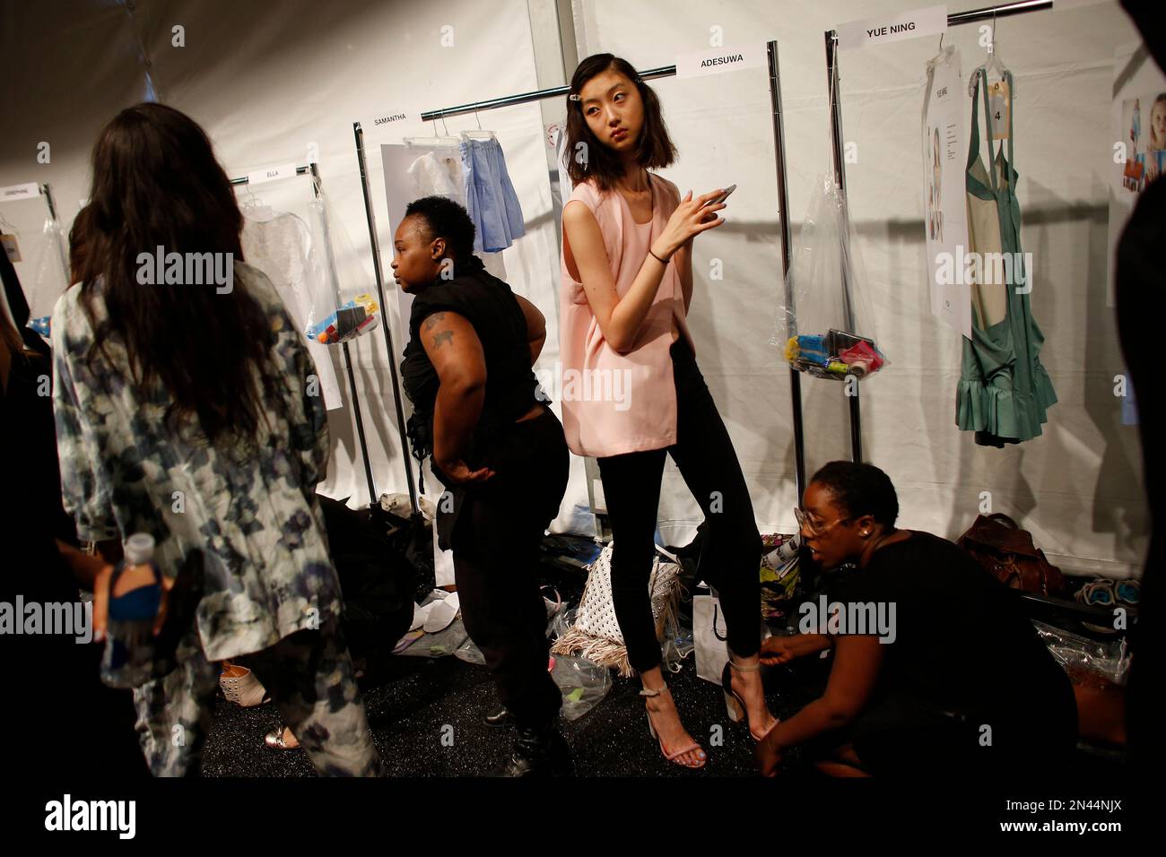 Model Yue Ning, of Beijing, China, tries on her shoes backstage before ...