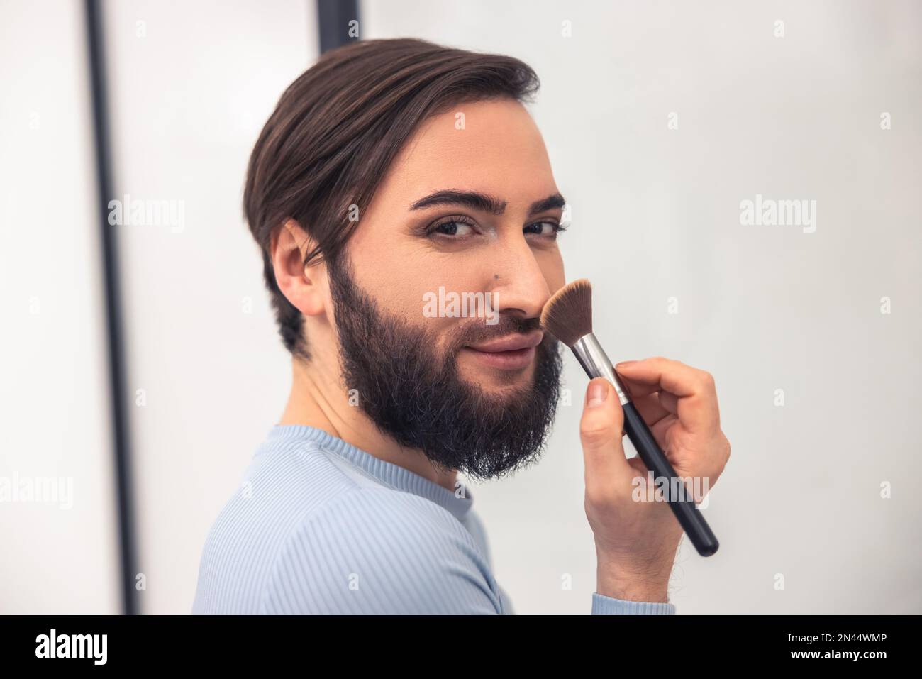 Transgender person applying powder to the face Stock Photo - Alamy