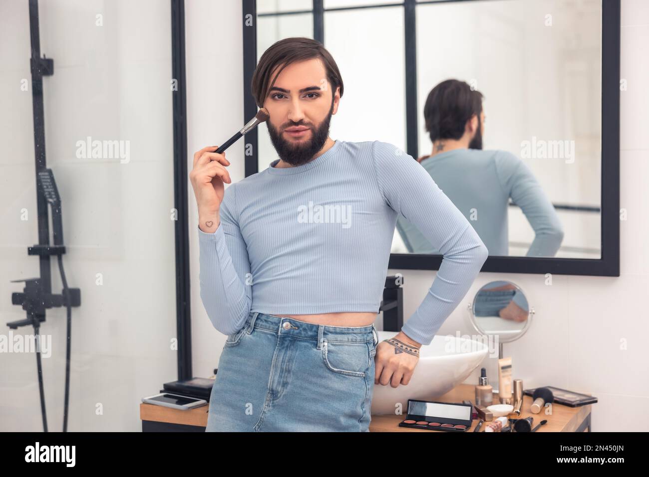 Guy applying powder to the face in the bathroom Stock Photo - Alamy