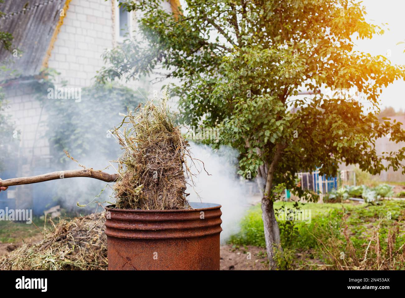 Burning dry grass and garbage in the country in the fall in an iron ...