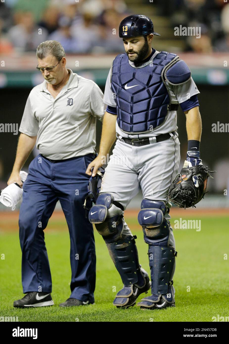Detroit Tigers' Alex Avila, right, walks off the field with a trainer ...