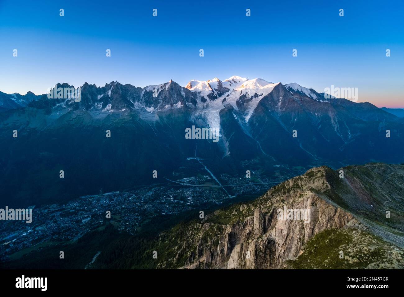 Aerial view on the town of Chamonix and the Mont Blanc massif, seen from Le Brevent at sunrise ...
