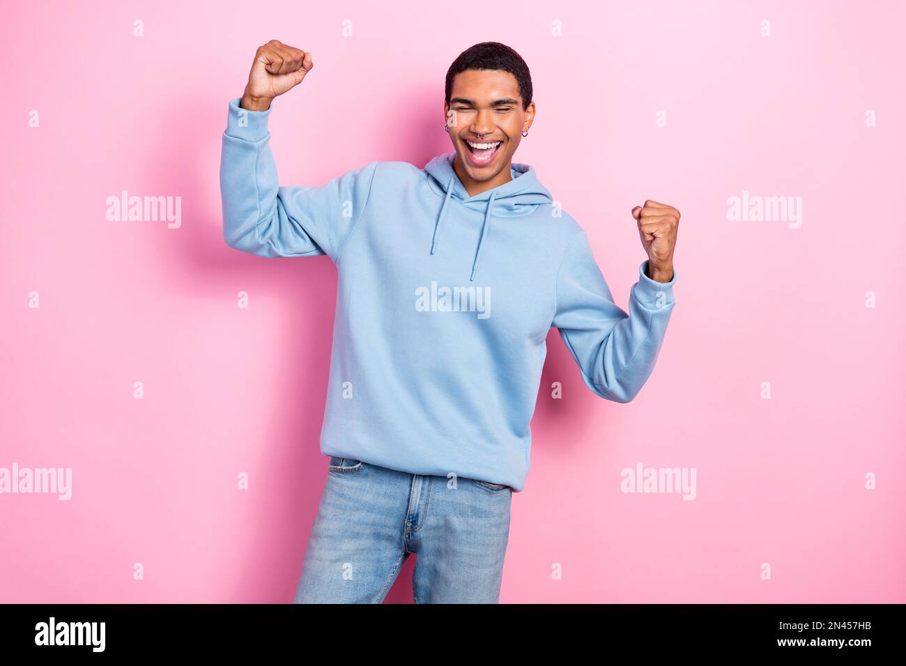 Photo of positive glad young man closed eyes scream yeah raise fists ...