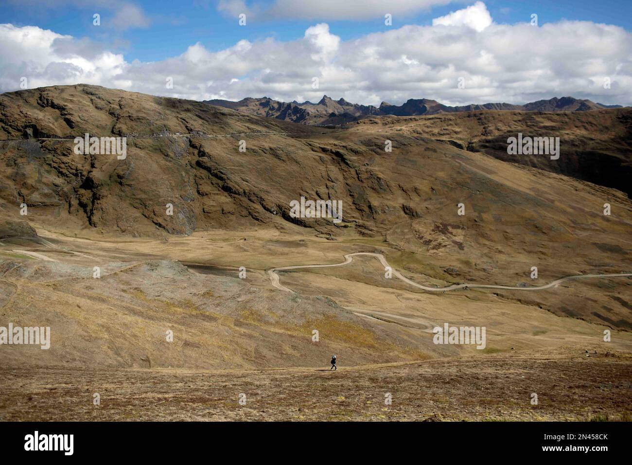 A man walks through a small path in the middle of the mountain in his ...