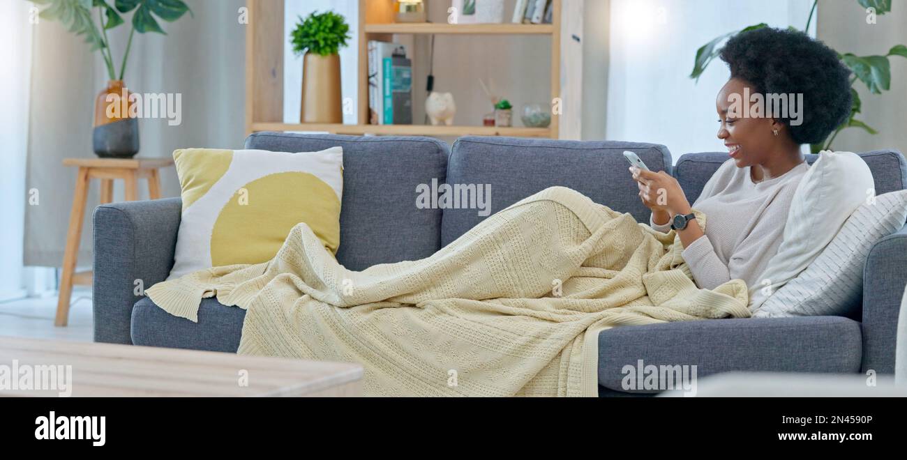 Happy black woman reading social media gossip on phone while relaxing ...