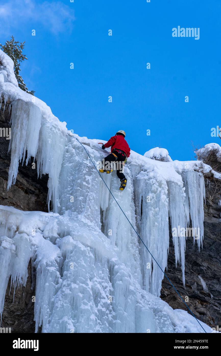 An ice climber tops out on a natural frozen waterfall in Price Canyon ...