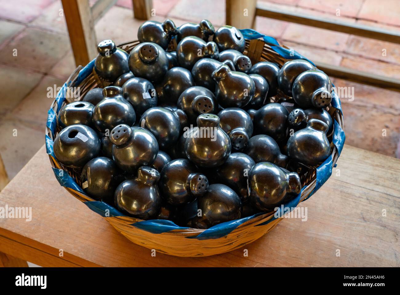 A basket of Oaxacan black ceramic salt and pepper shakers in a pottery ...