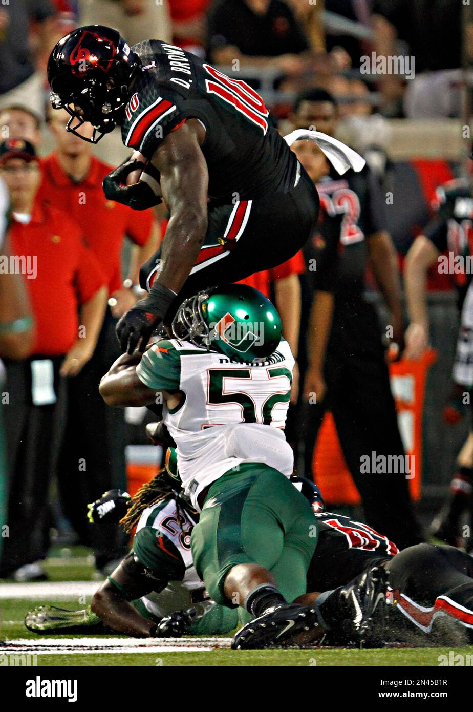 Louisville running back Dominique Brown (10) tries to hurdle Miami ...