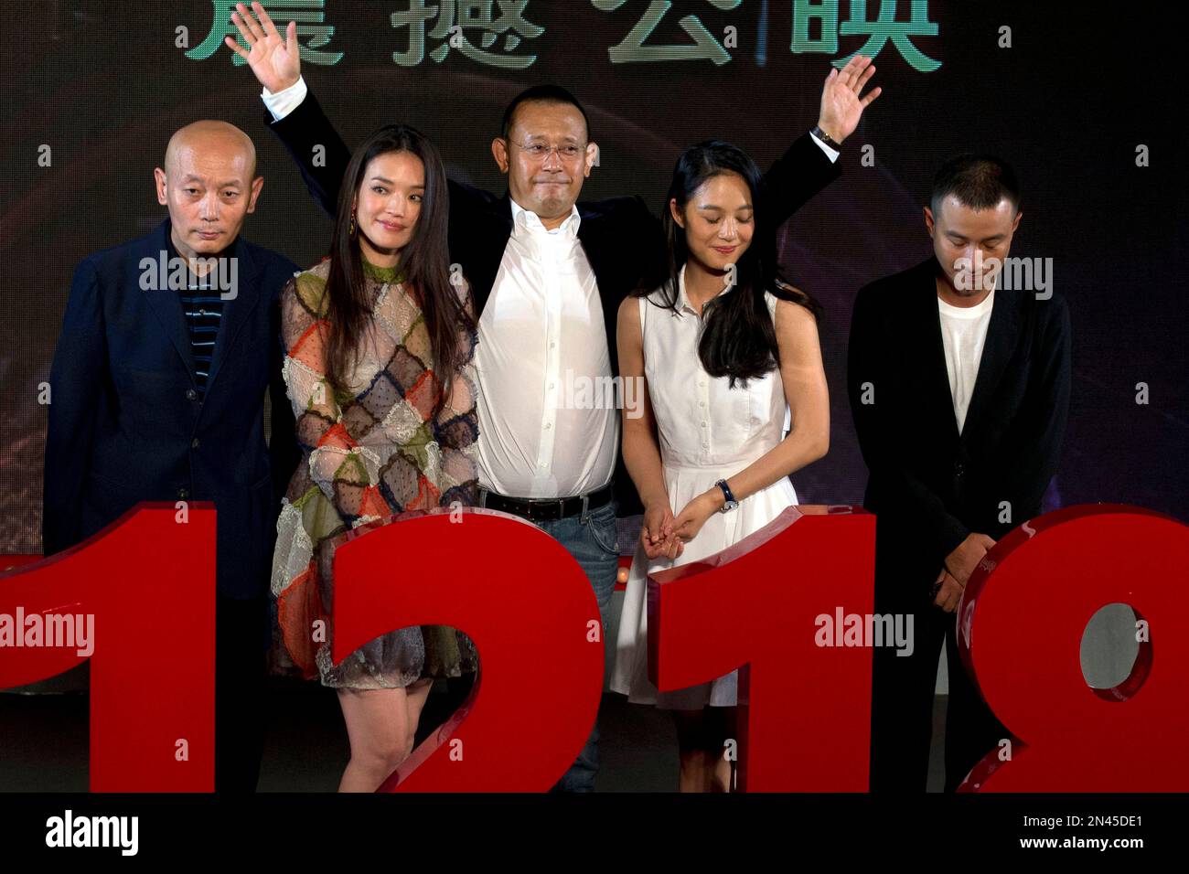 Chinese director Jiang Wen, center, waves near cast members from right ...