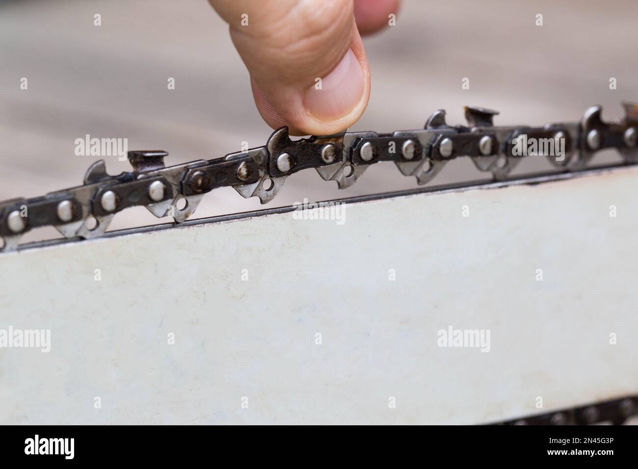 Correct chain tension using the special tool on the chainsaw bar. Chain ...