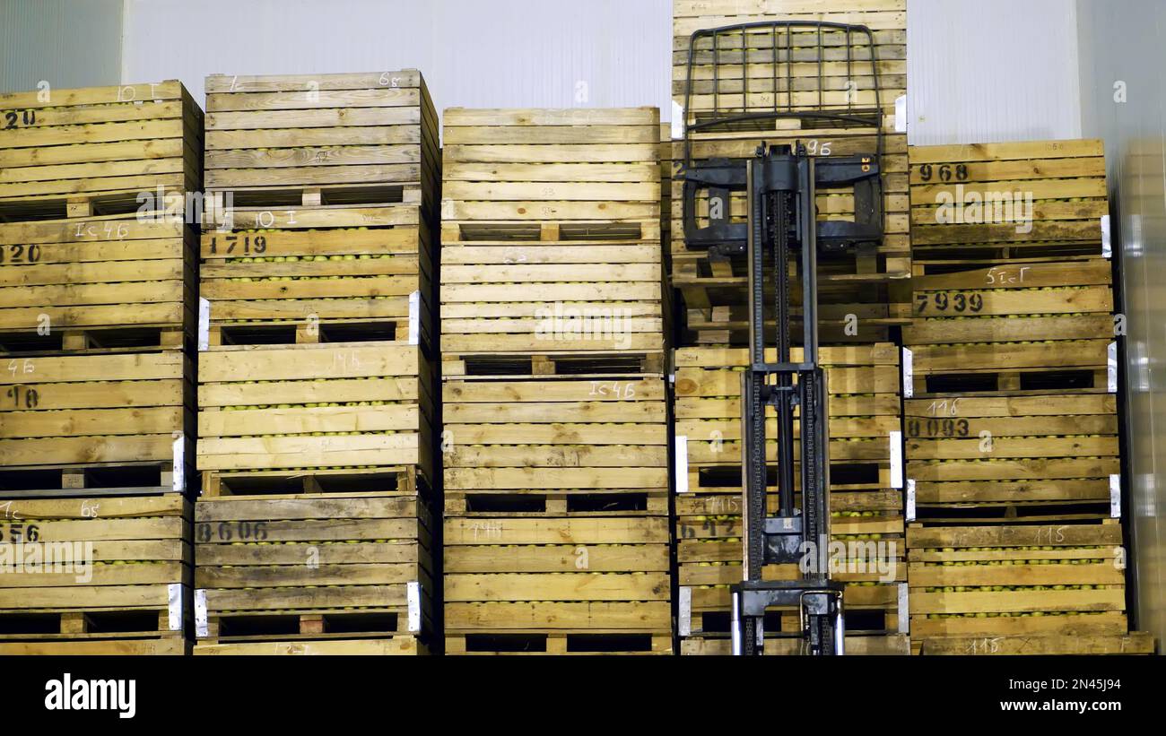 A special machine, loader, forklift truck puts large wooden boxes with ...
