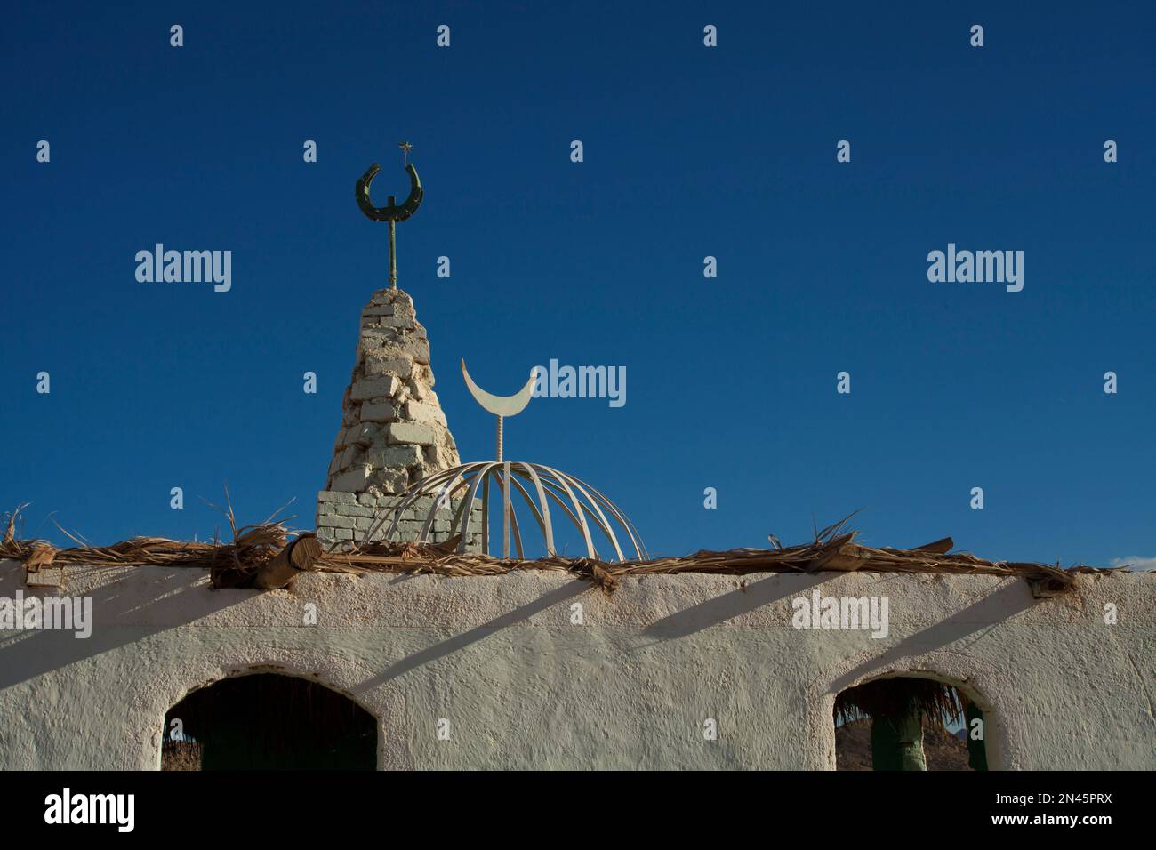 Crescent moon on roof of mosque in Egypt desert - blue sky background ...