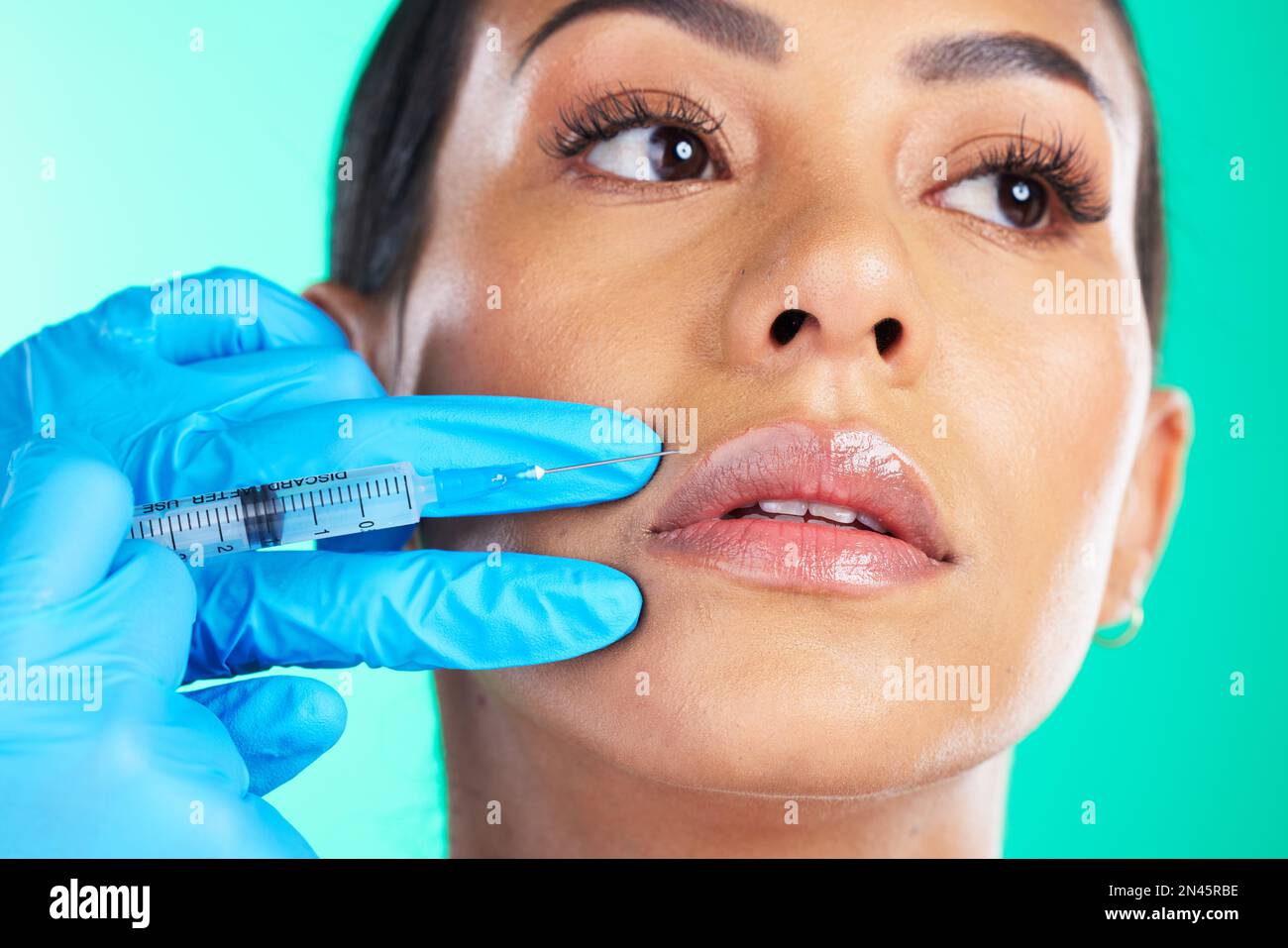 Woman, face and hands with syringe for botox, plastic surgery or lip ...
