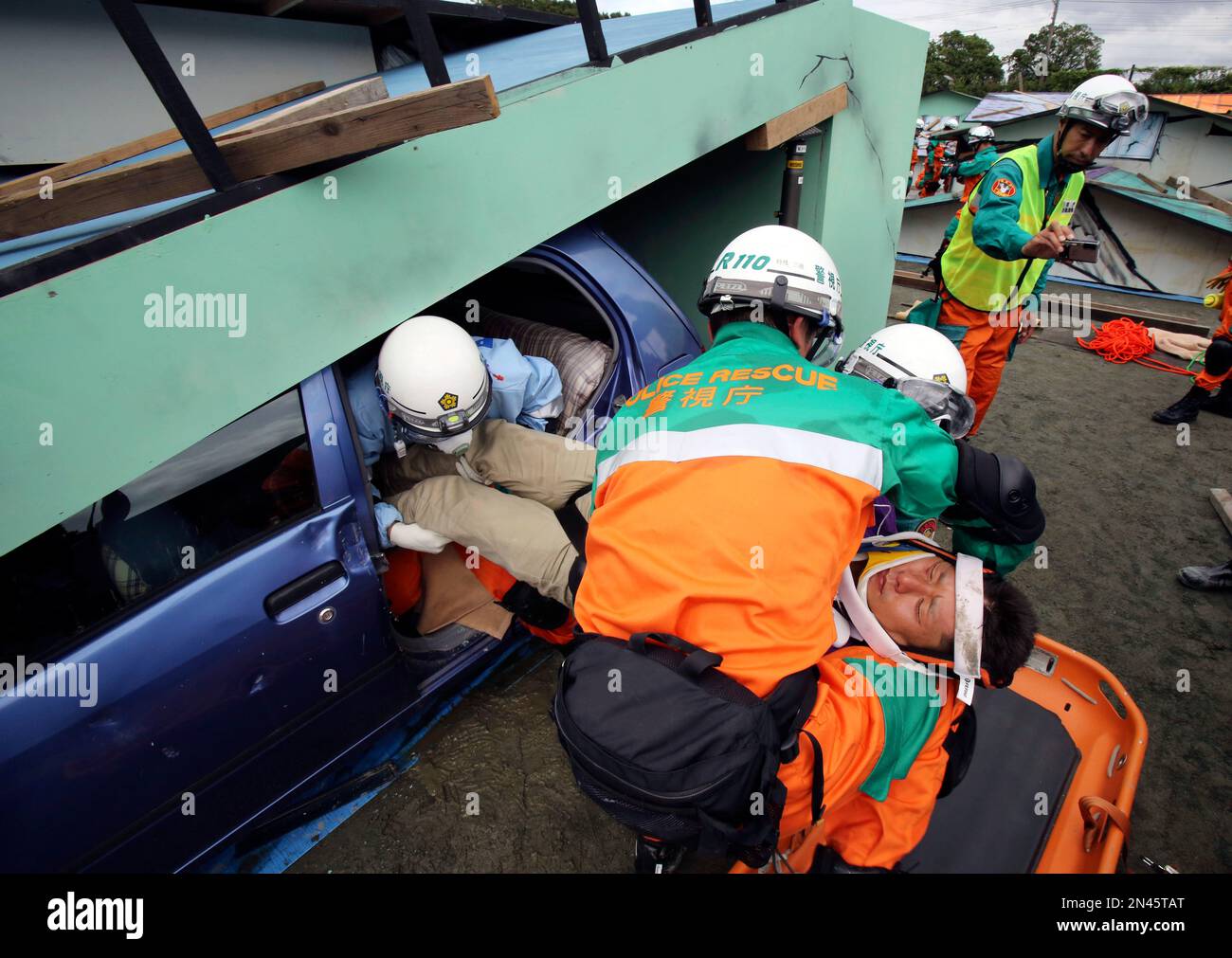 Tokyo Metropolitan Police members rescue a person playing the roll of ...