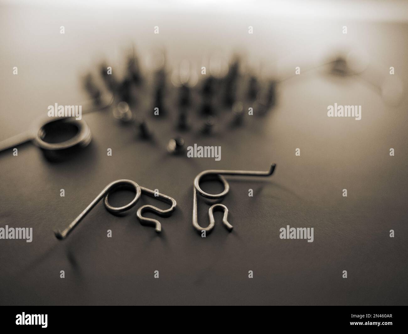 A closeup grayscale of torsion springs on a table against the isolated ...