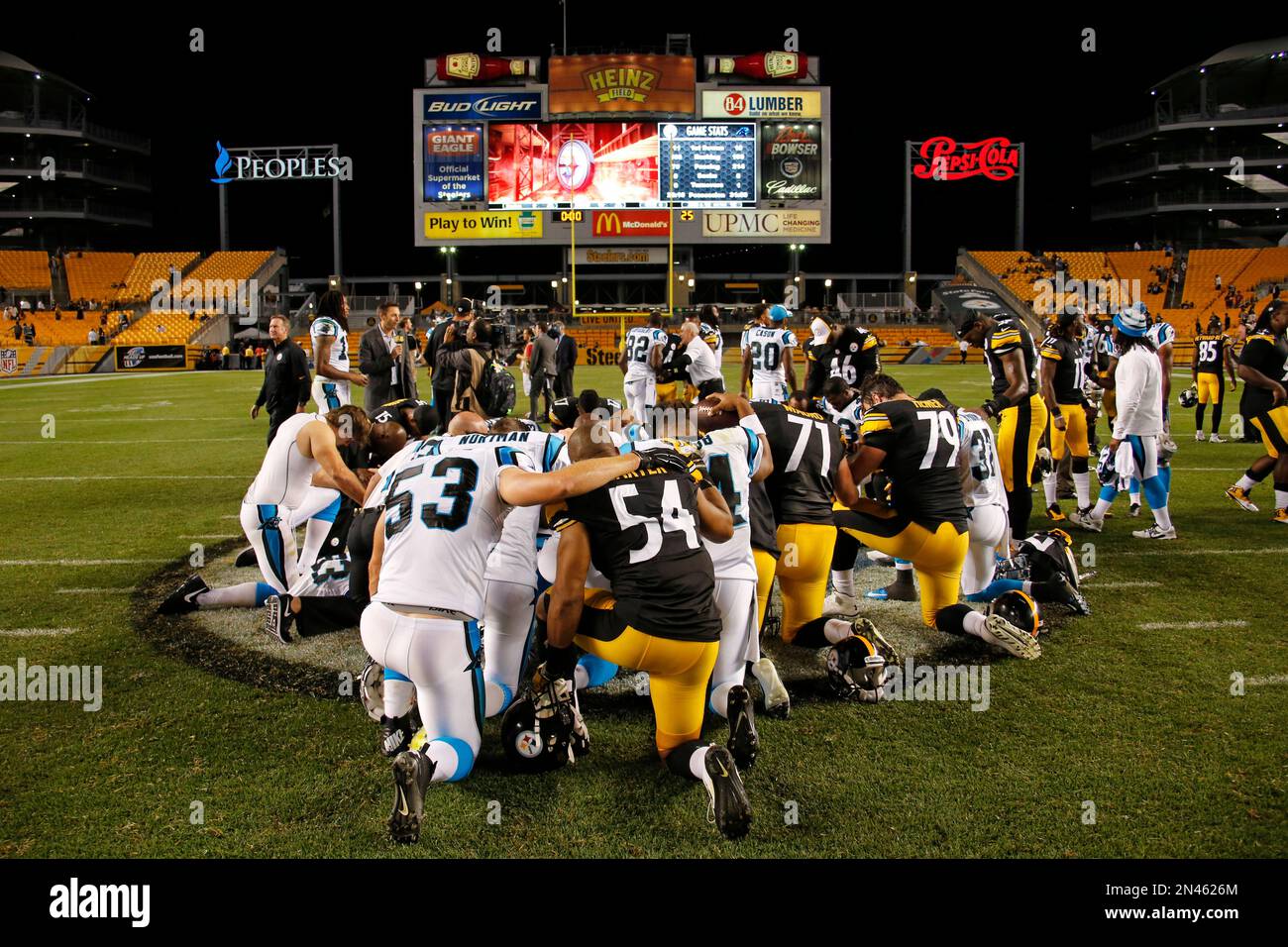 Carolina Panthers and Pittsburgh Steelers players gather at mid-field ...