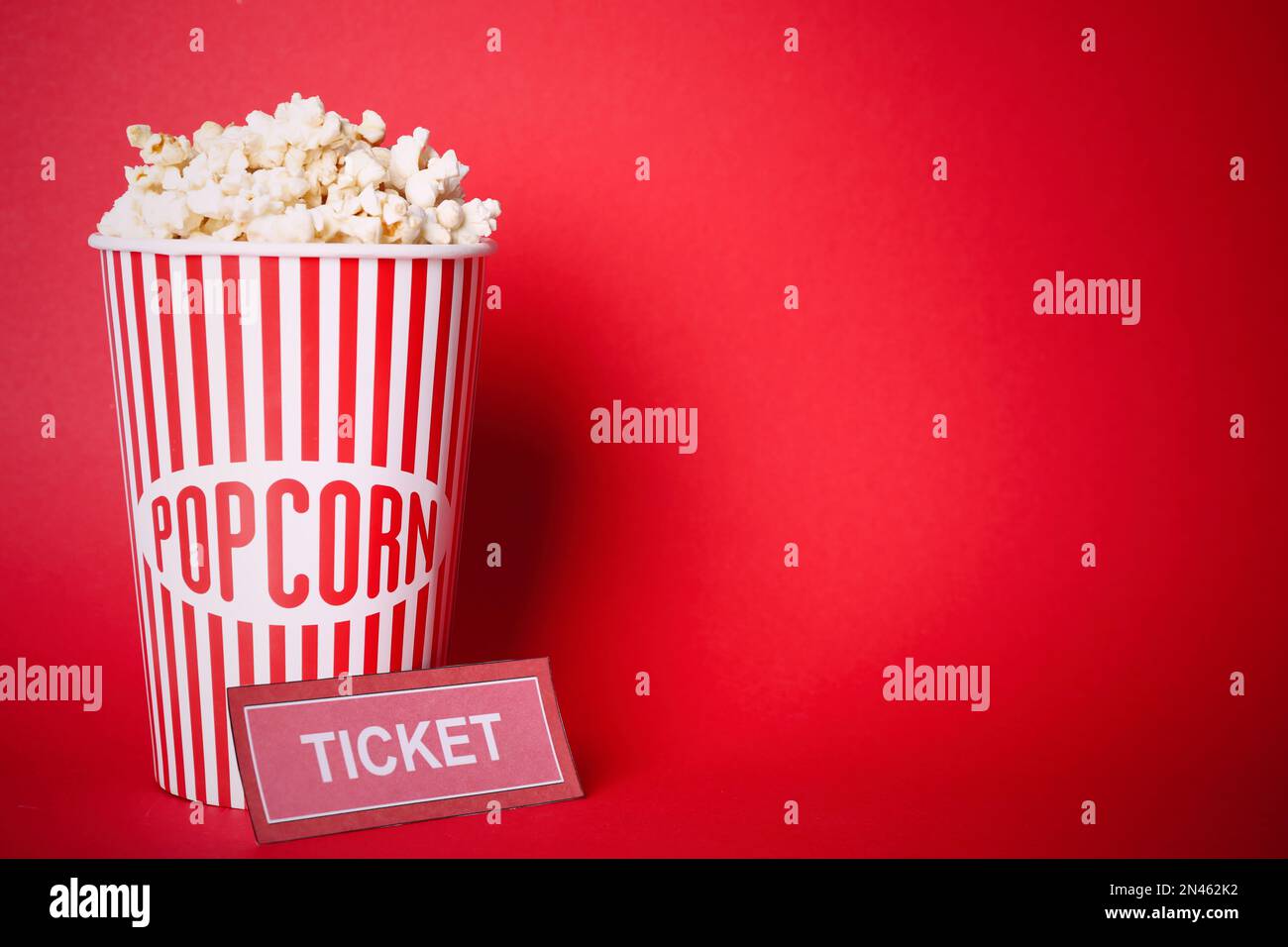 Delicious popcorn and ticket on red background. Space for text Stock ...