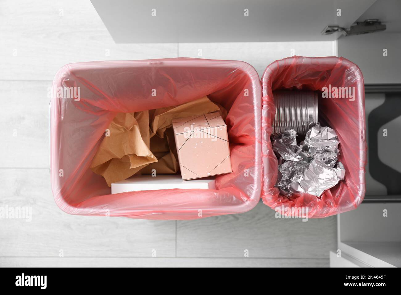 Open cabinet with full trash bins for separate waste collection in ...