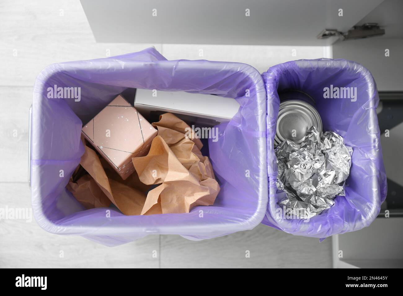 Open cabinet with full trash bins for separate waste collection in ...