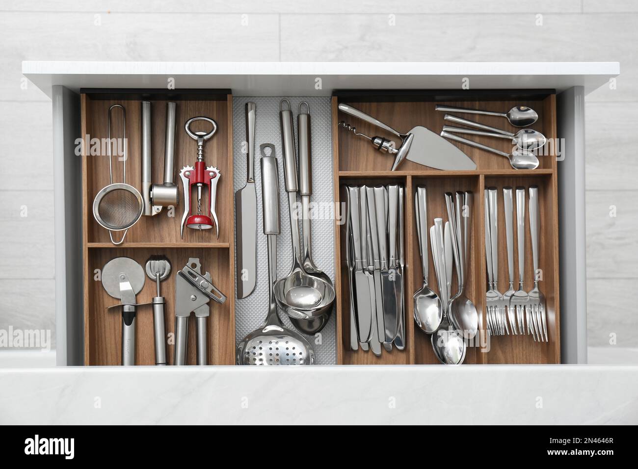 Open drawer with different utensils and cutlery in kitchen, top view ...